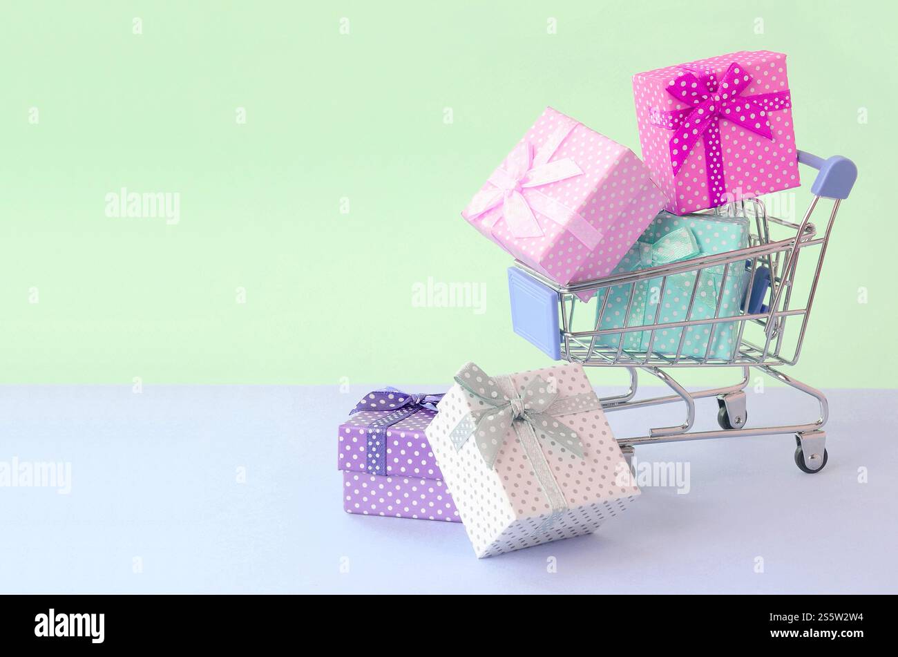 Small gift boxes of different colors with ribbons lies in shopping cart ...