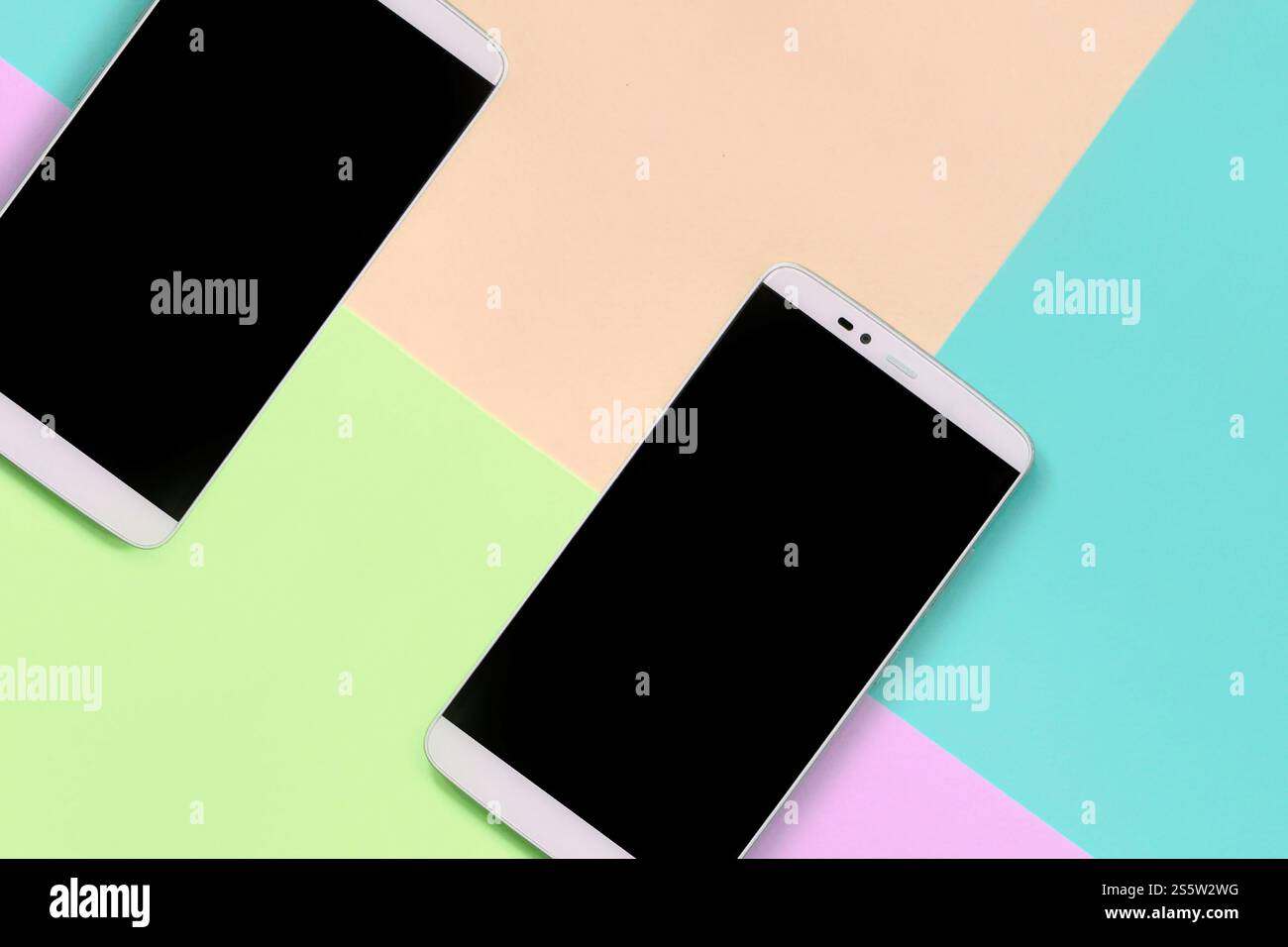 Two modern smartphones with black screens on texture background of ...