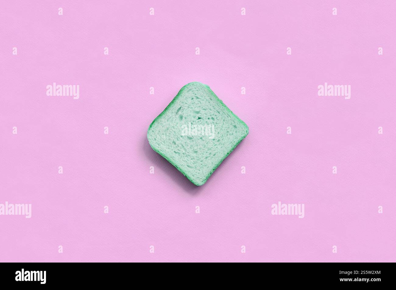A piece of green bread lies on texture background of fashion pastel ...