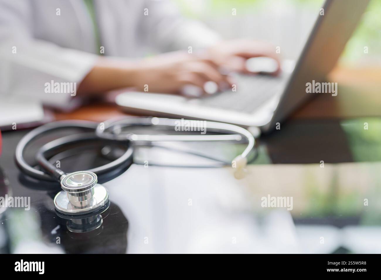 Doctor consult patient on laptop with anatomical model of human heart ...