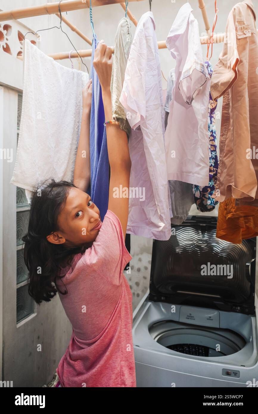 Asian teen girl doing laundry Stock Photo - Alamy