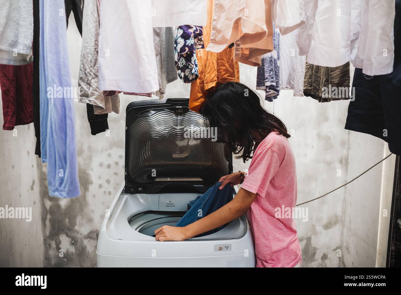 Asian teen girl doing laundry Stock Photo - Alamy