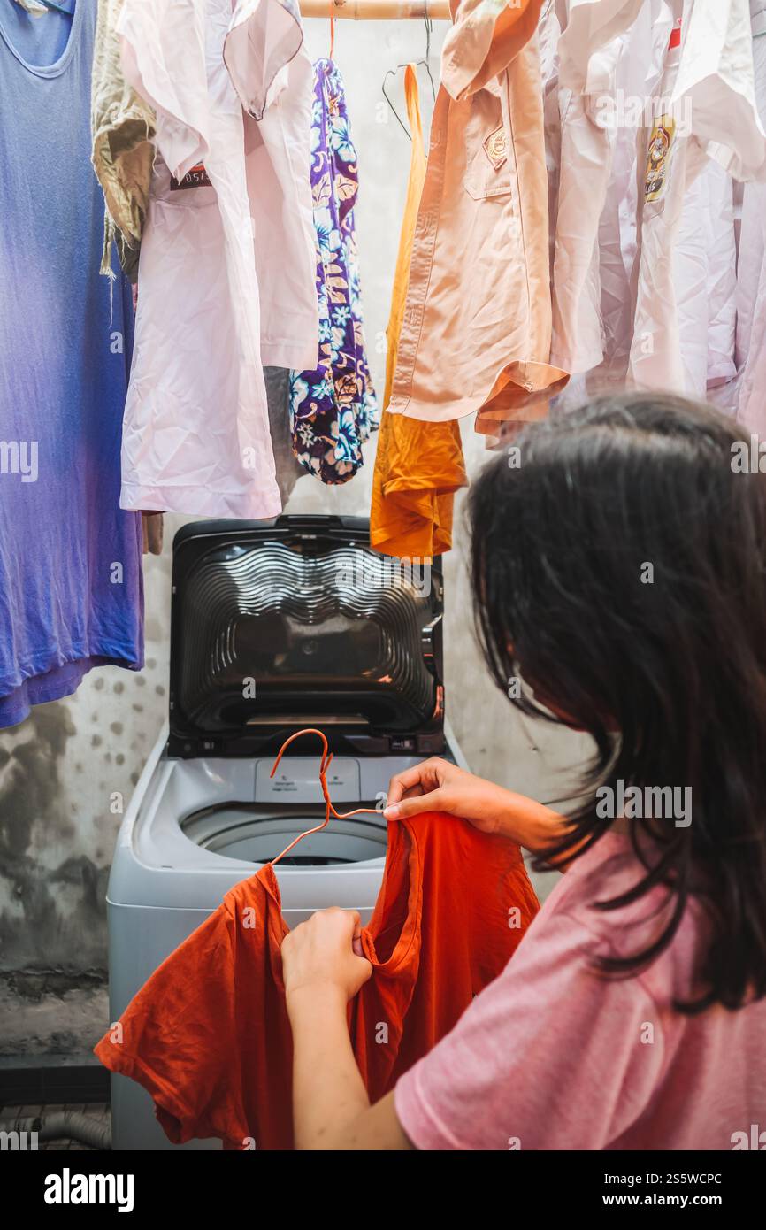 Asian teen girl doing laundry at home Stock Photo - Alamy