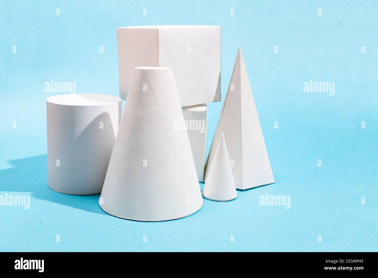 different handmade paper geometric objects on turquoise blue background ...