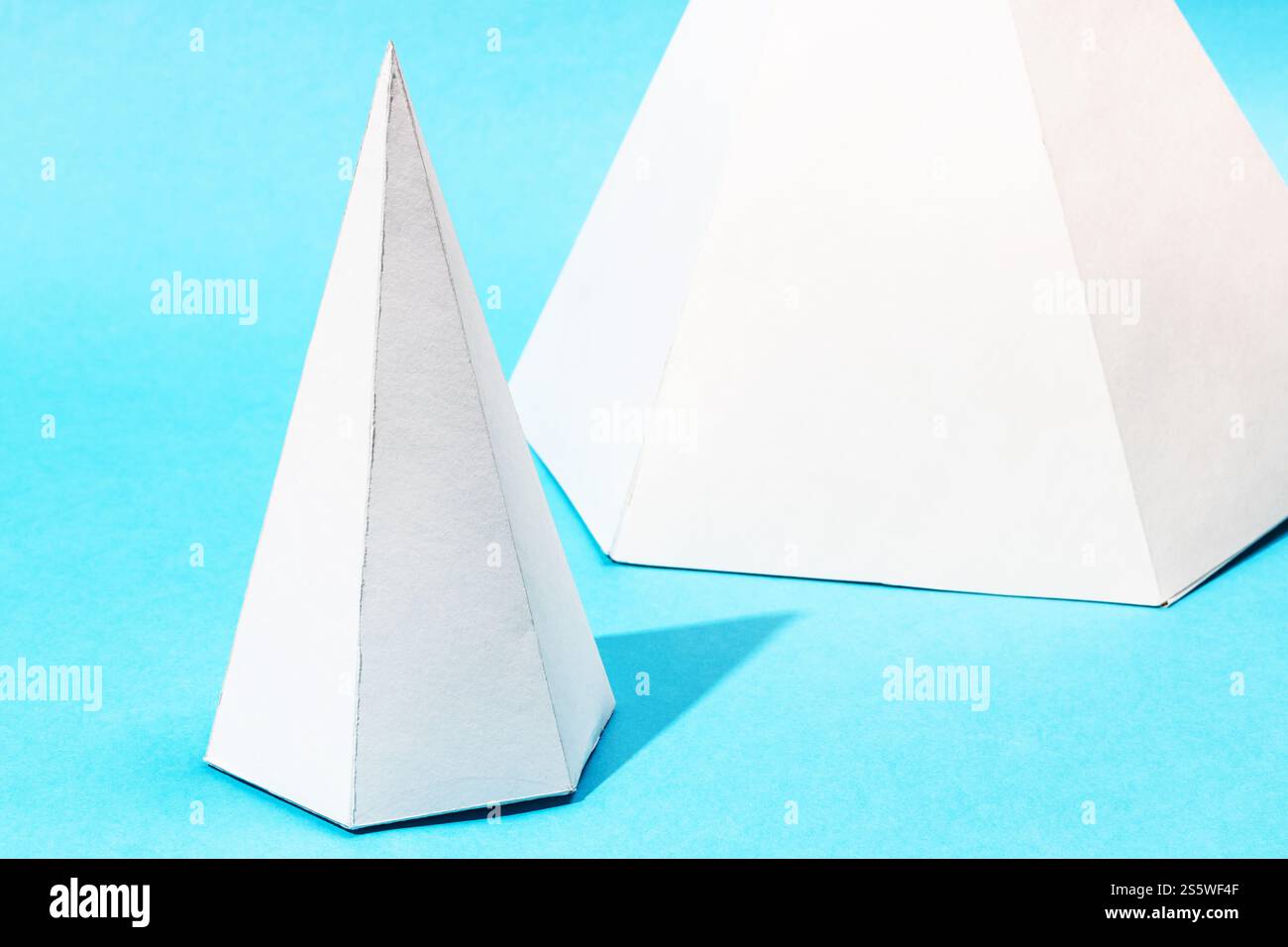 handmade paper pyramids close up on turquoise blue background Stock ...
