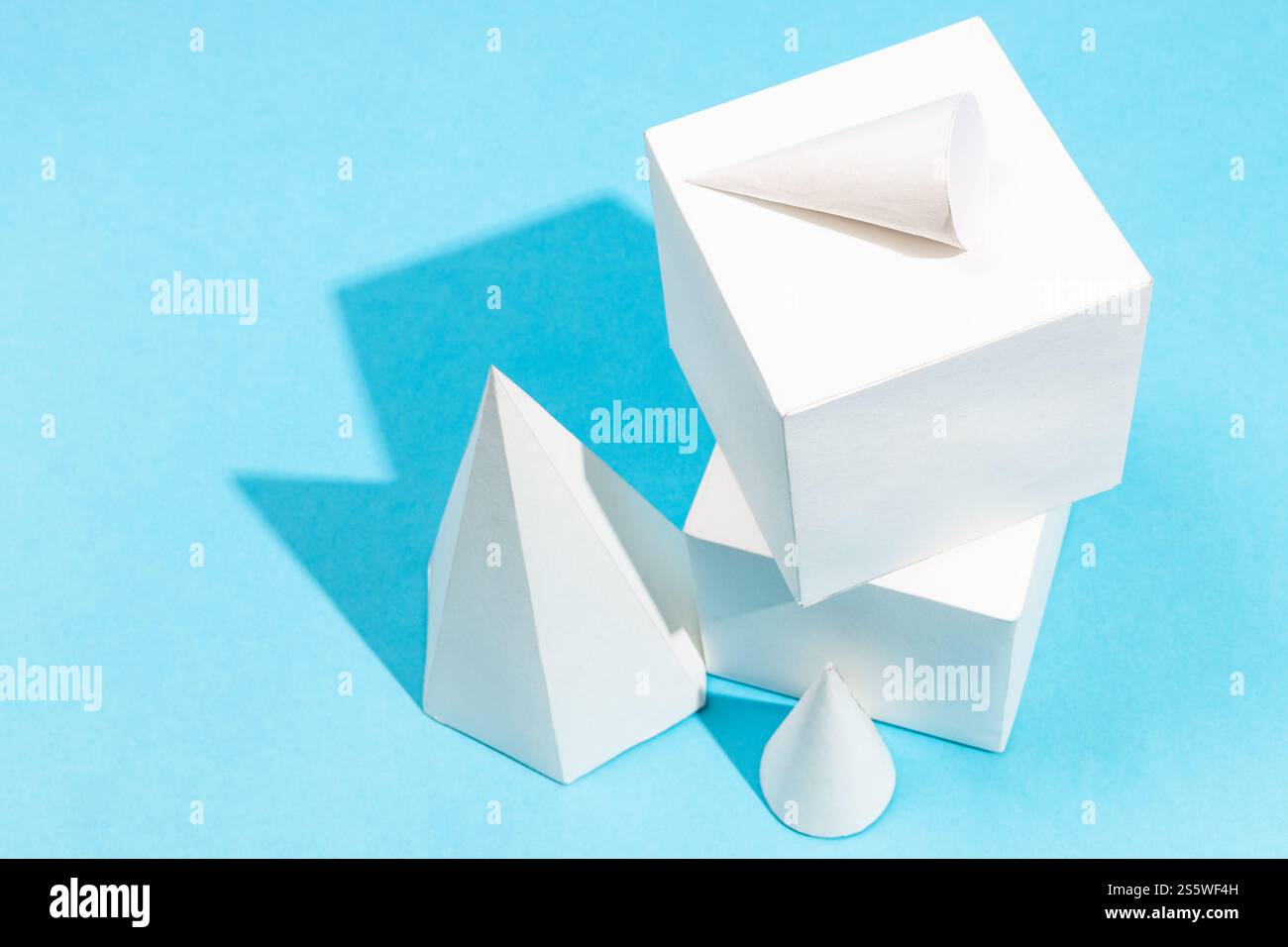 top view of handmade paper geometric solids (cones, cubes, pyramid) on ...