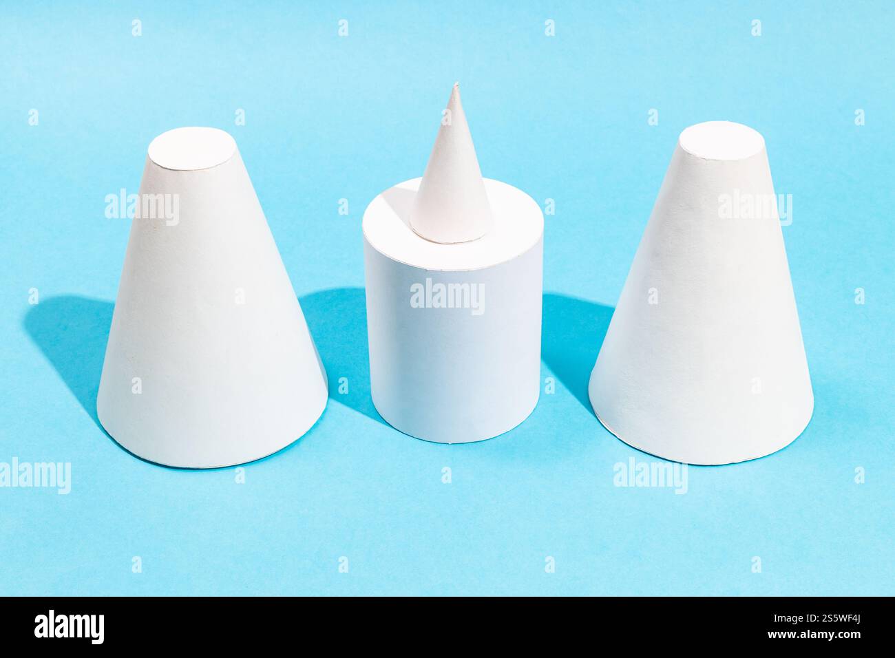 handmade various paper cones and cylinder on turquoise blue background ...