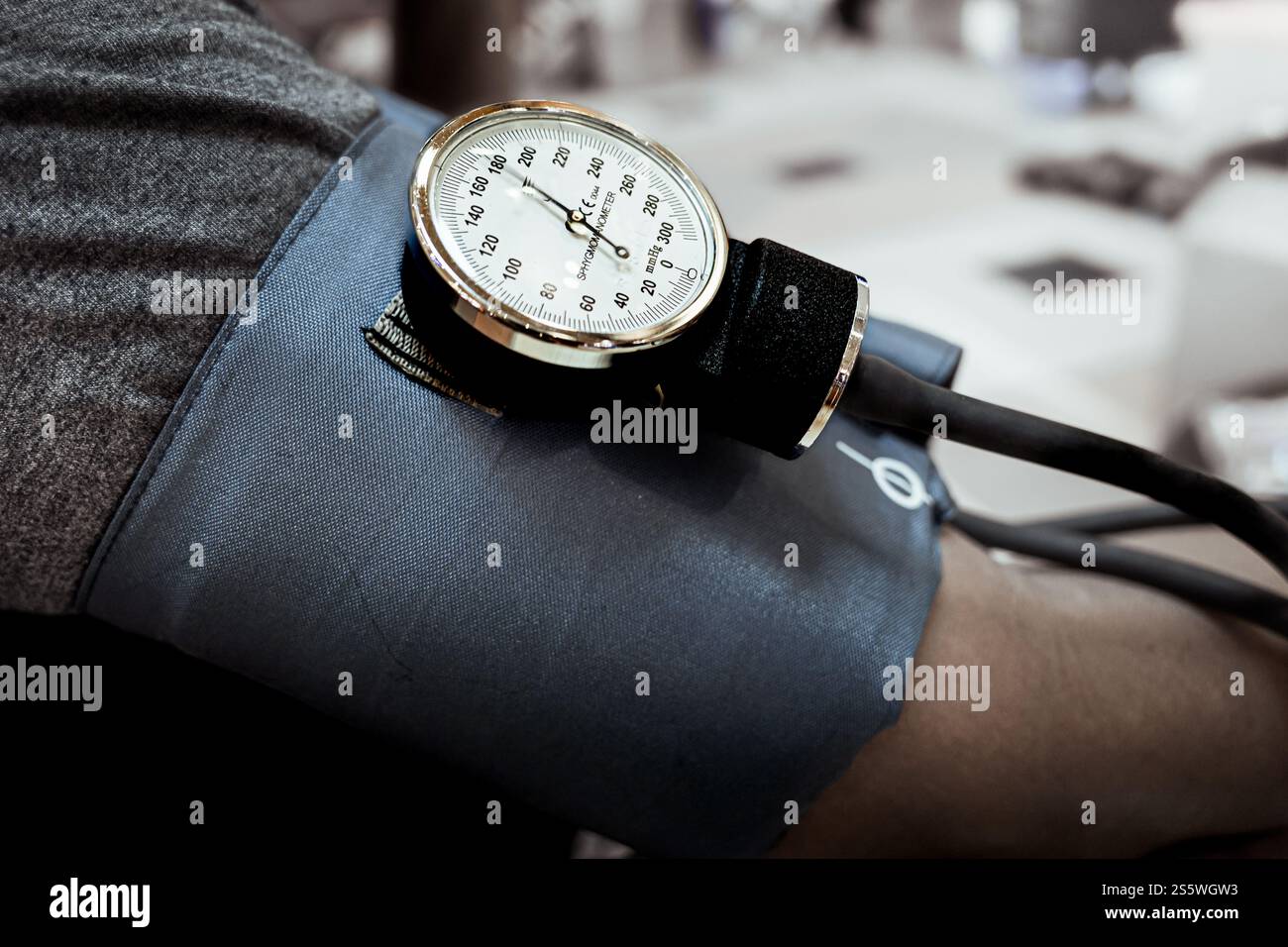 Closeup of analog blood pressure measuring device placed on adult man's ...