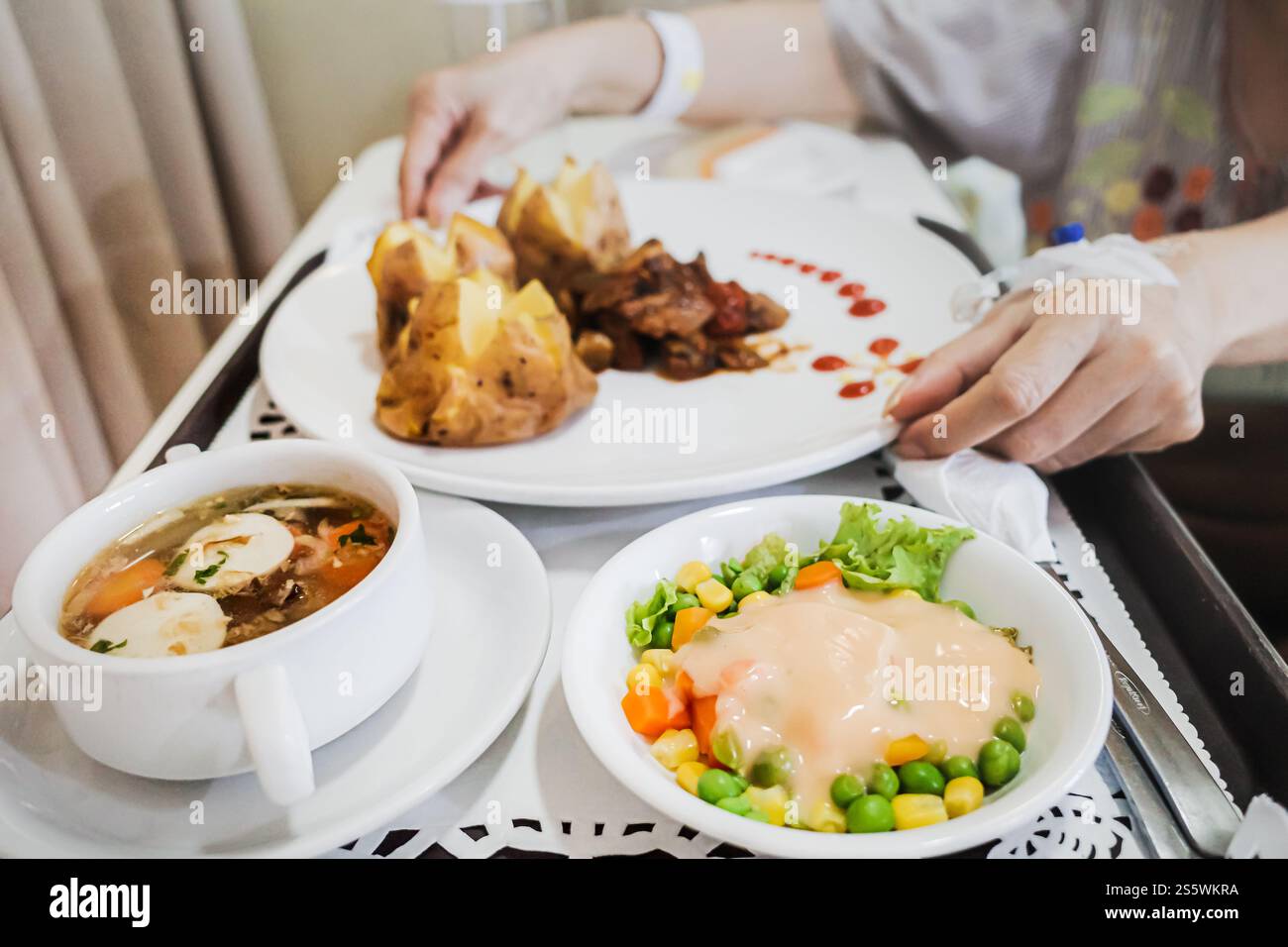 Female patient hands ready to eat a tray full of healthy dietary vegan ...