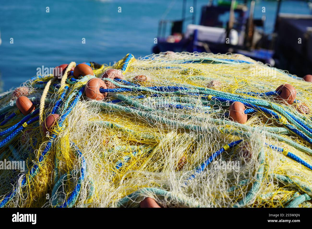 A close up of fishing nets and in the background the sea and a fishing ...