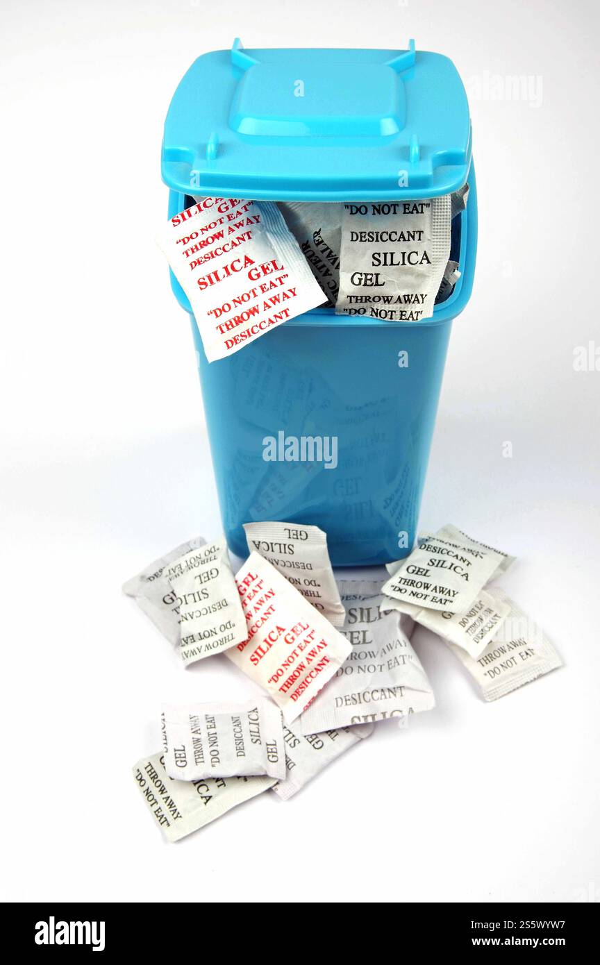 silica gel packets in a blue rubbish bin with excess gel packets around ...