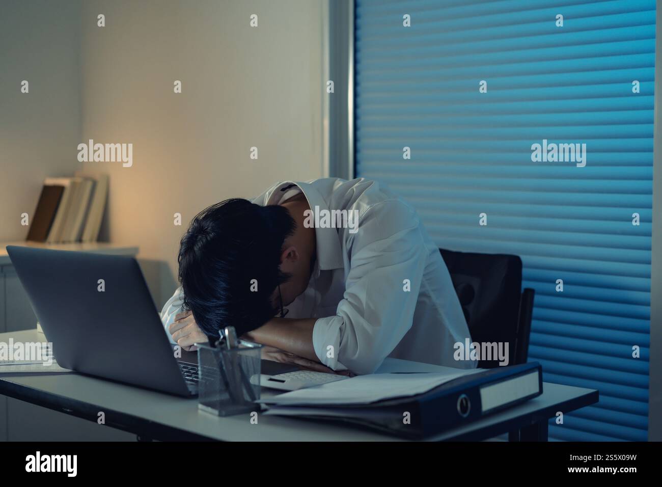 Tired Asian business man falling asleep at table Alone Working holding ...