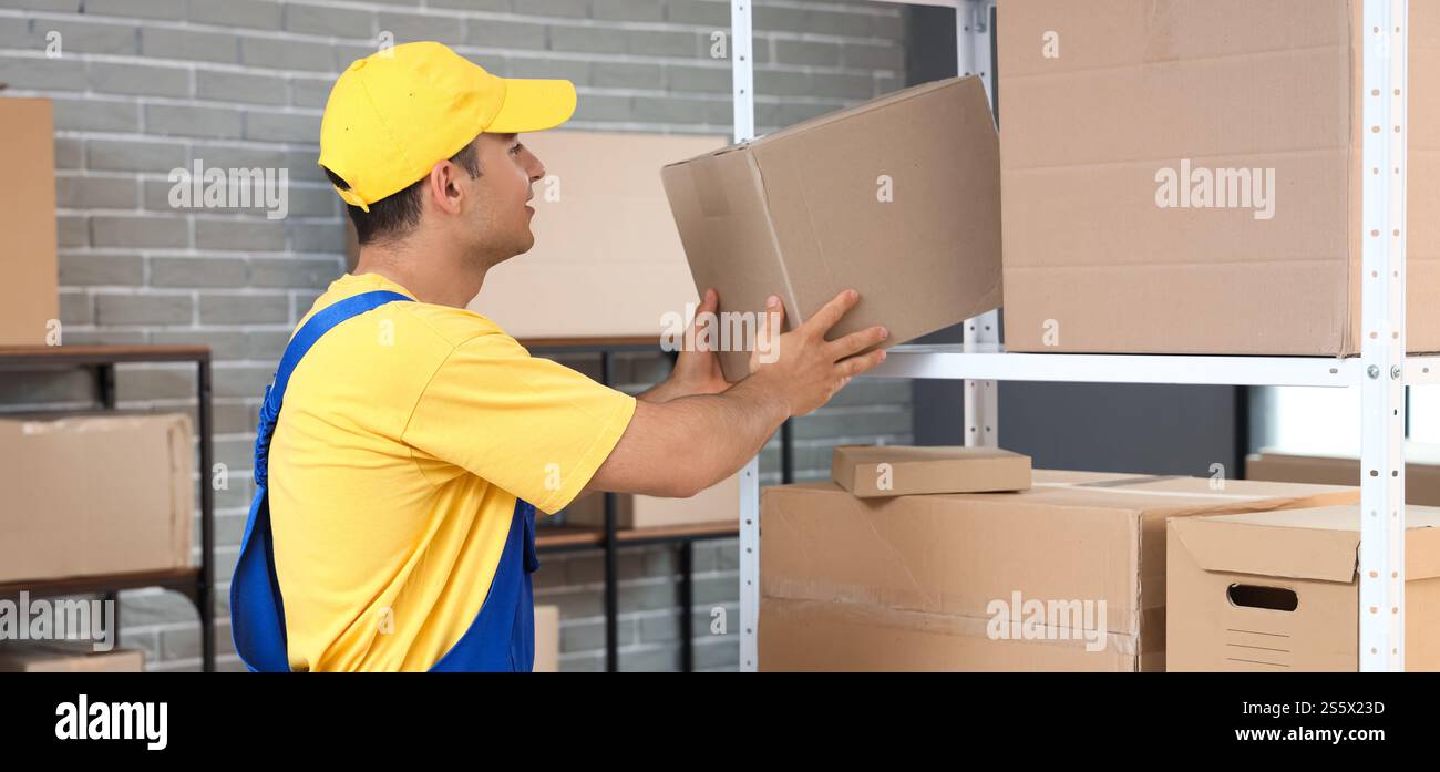 Delivery man taking parcel box from shelf in warehouse Stock Photo - Alamy