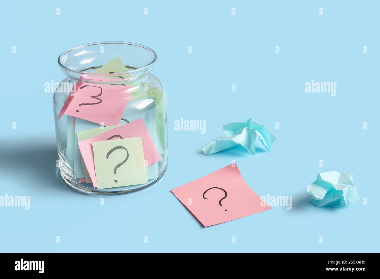 Glass jar full of sticky notes with question marks on color background ...