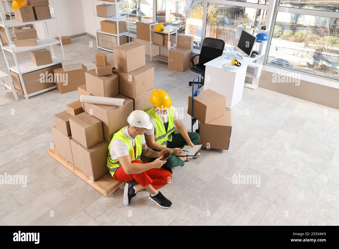 Male loaders with clipboard and tablet computer working in warehouse ...