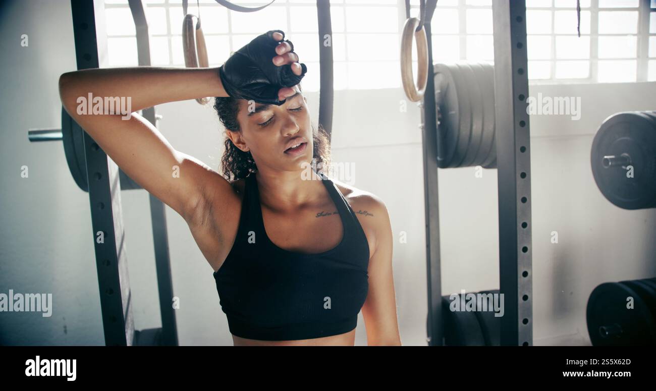 Fitness, tired woman and bodybuilder sweating in gym on break for ...