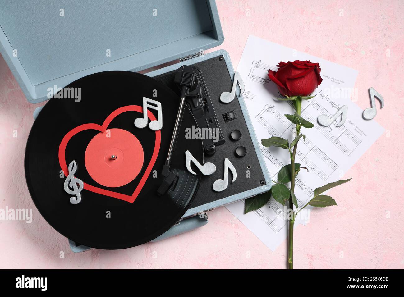 Composition with rose flower, record player, sheet notes and decorative ...