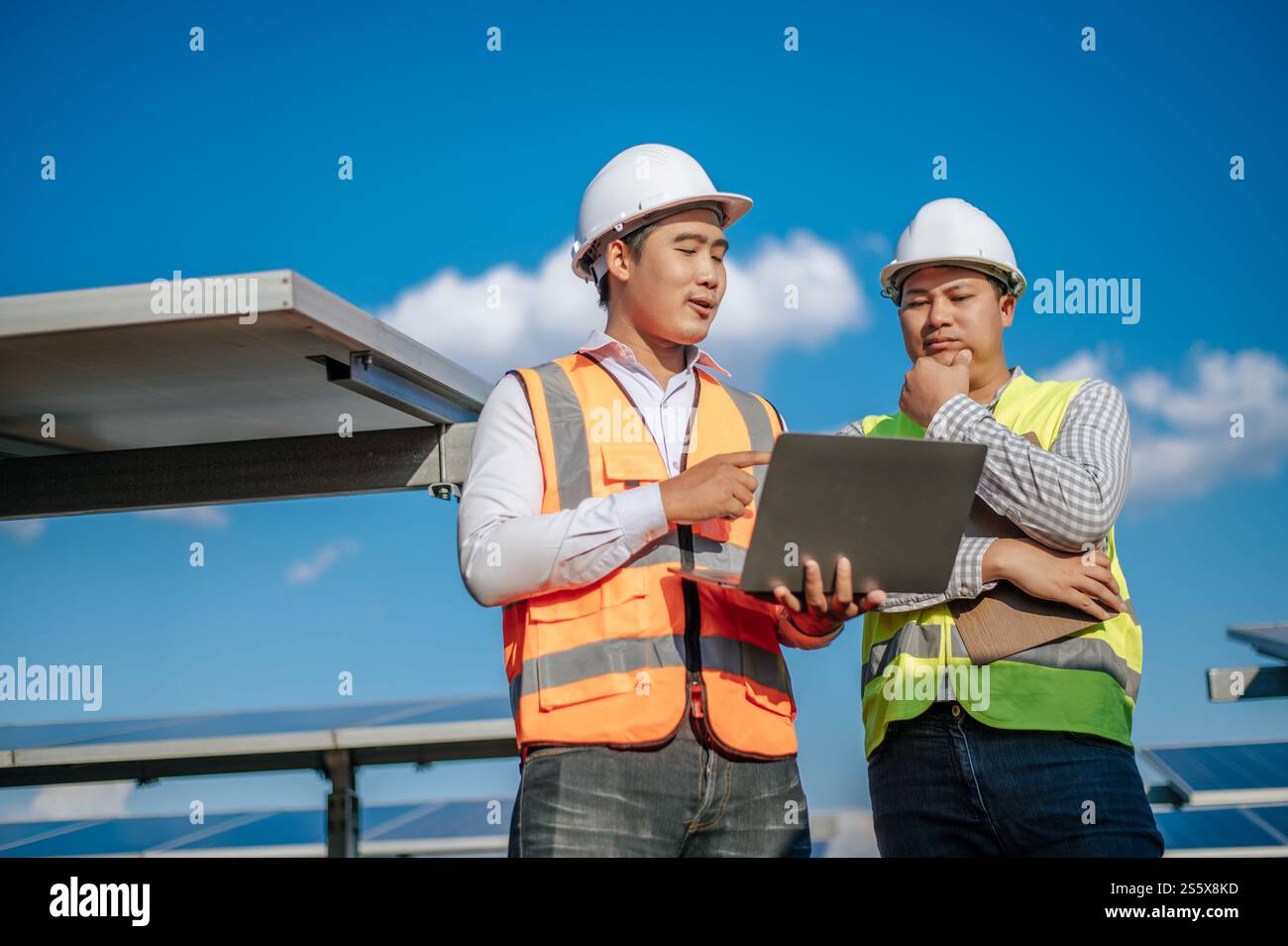 Young Asian technician man and colleague in safety uniform checking ...