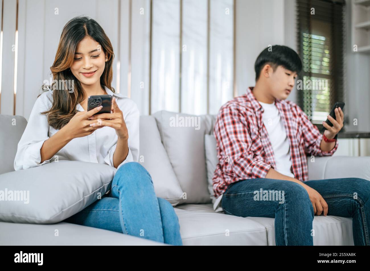 Selective focus, Young Asian Couple sitting on sofa in living room, They are enjoy with social ...