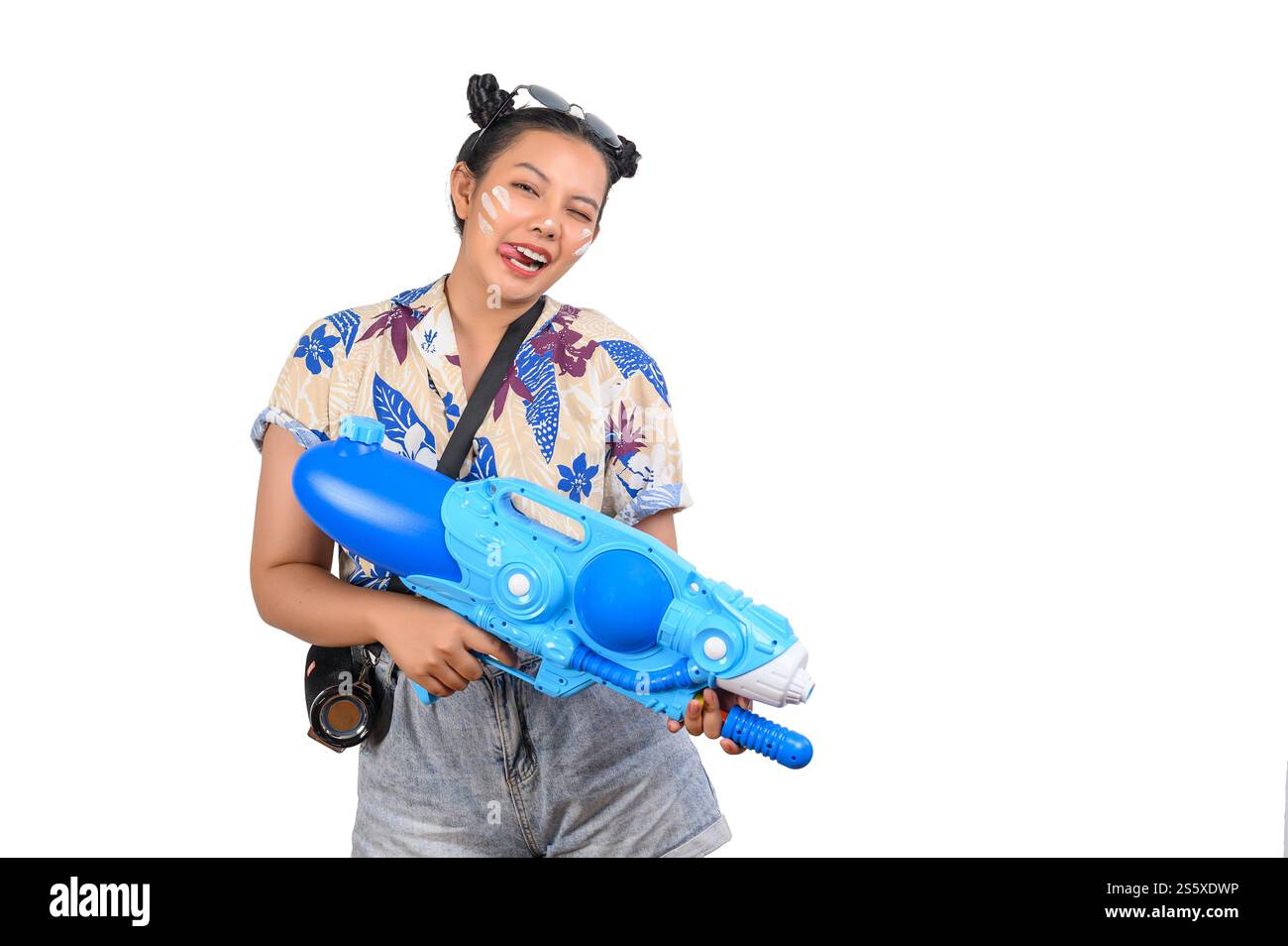 Portrait lovely woman in floral shirt and short jeans holding water gun ...