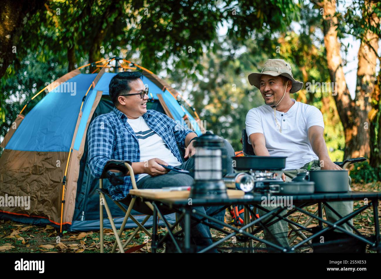Portrait happy Asian man friends sitting on chair in the camp with ...
