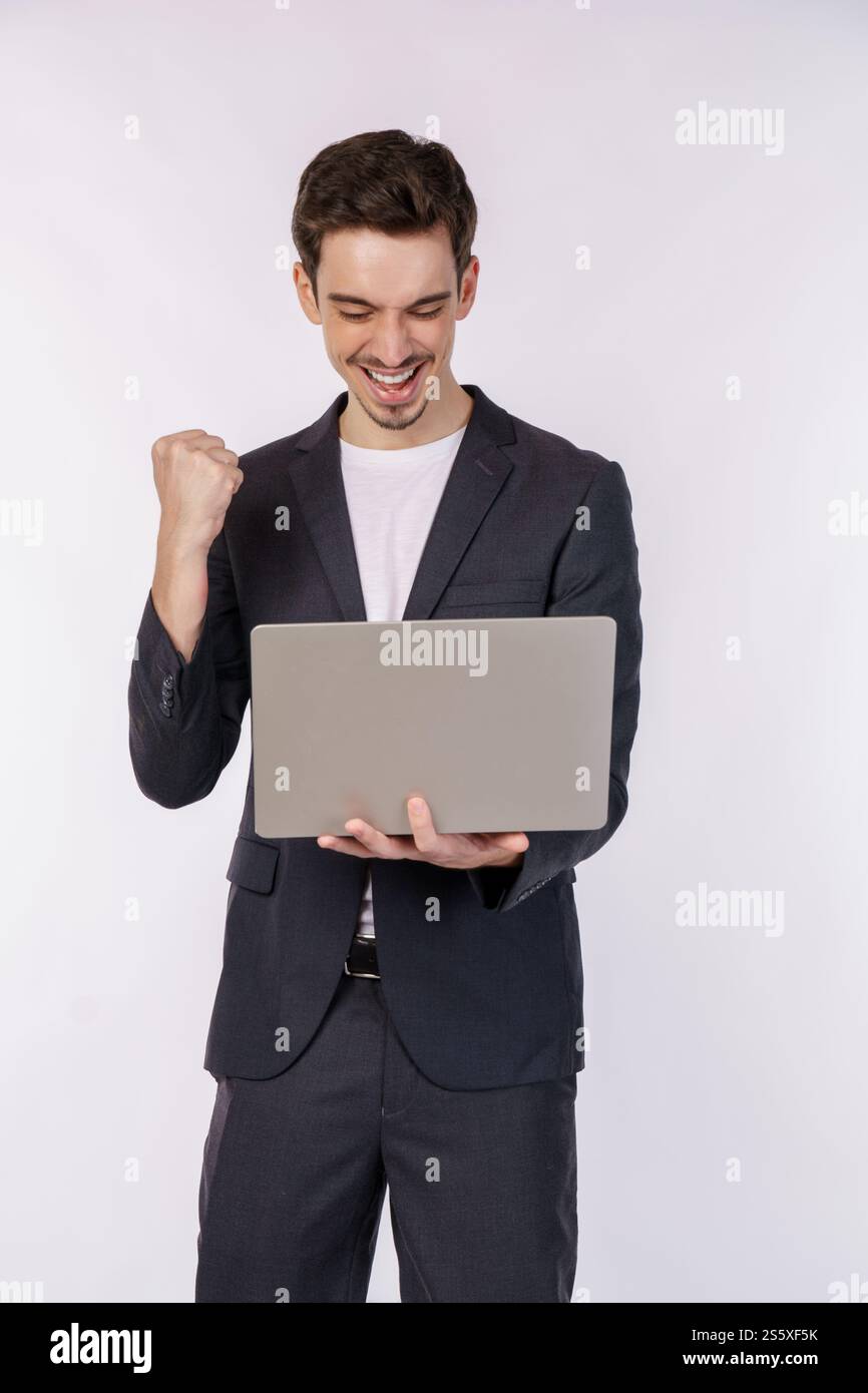 Portrait of young smiling businessman holding laptop in hands, typing ...