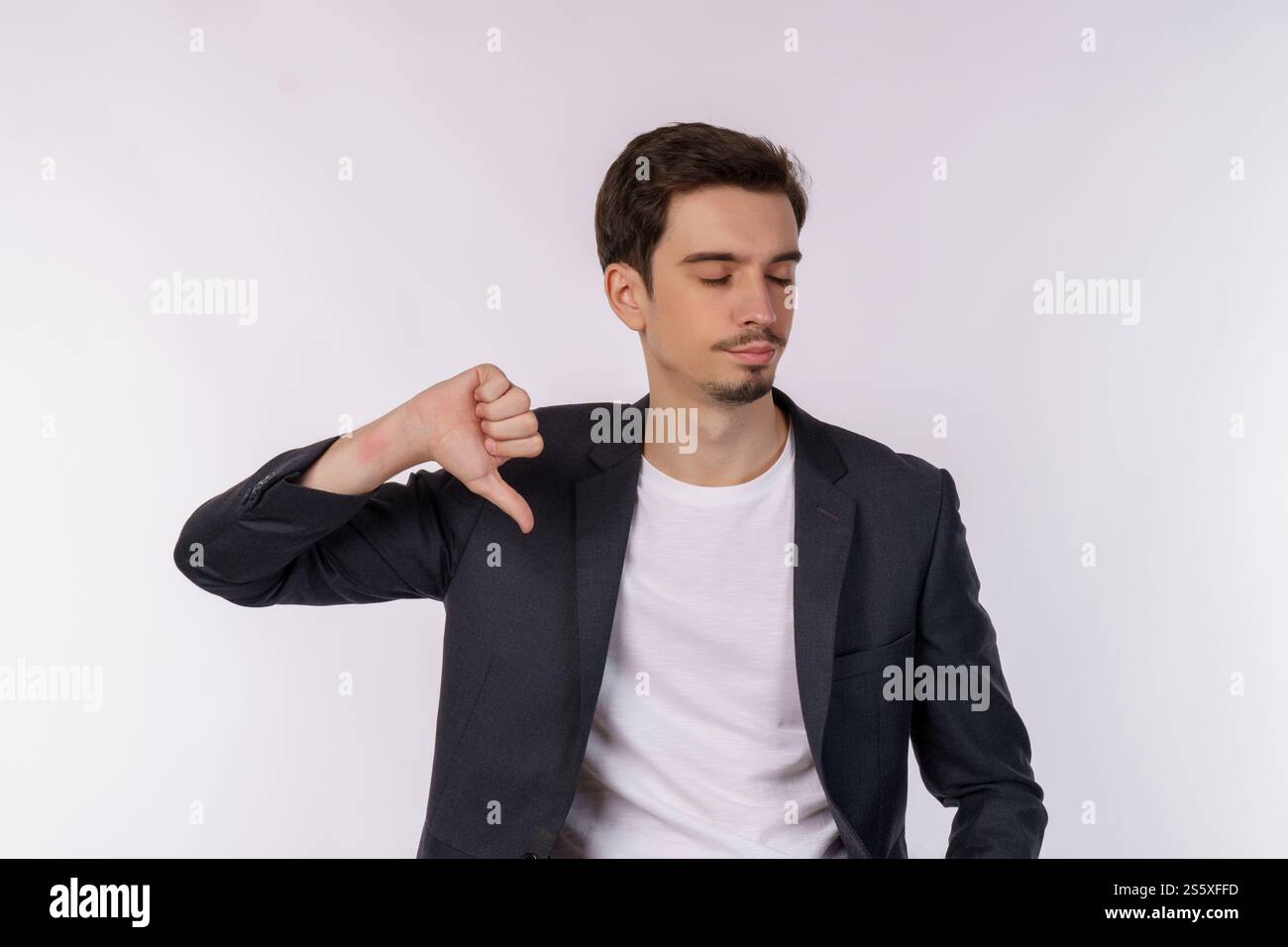 Portrait of young businessman shows sign of dislike, looks with ...
