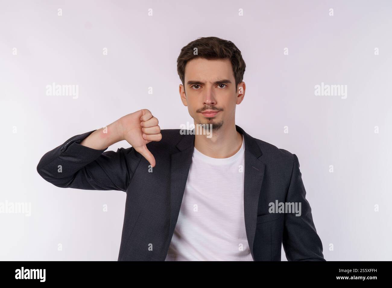 Portrait of young businessman shows sign of dislike, looks with ...
