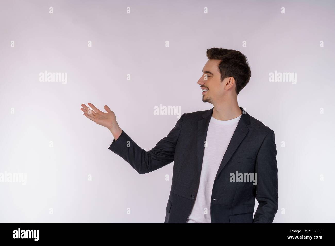 Portrait of happy smiling young businessman presenting and showing your ...