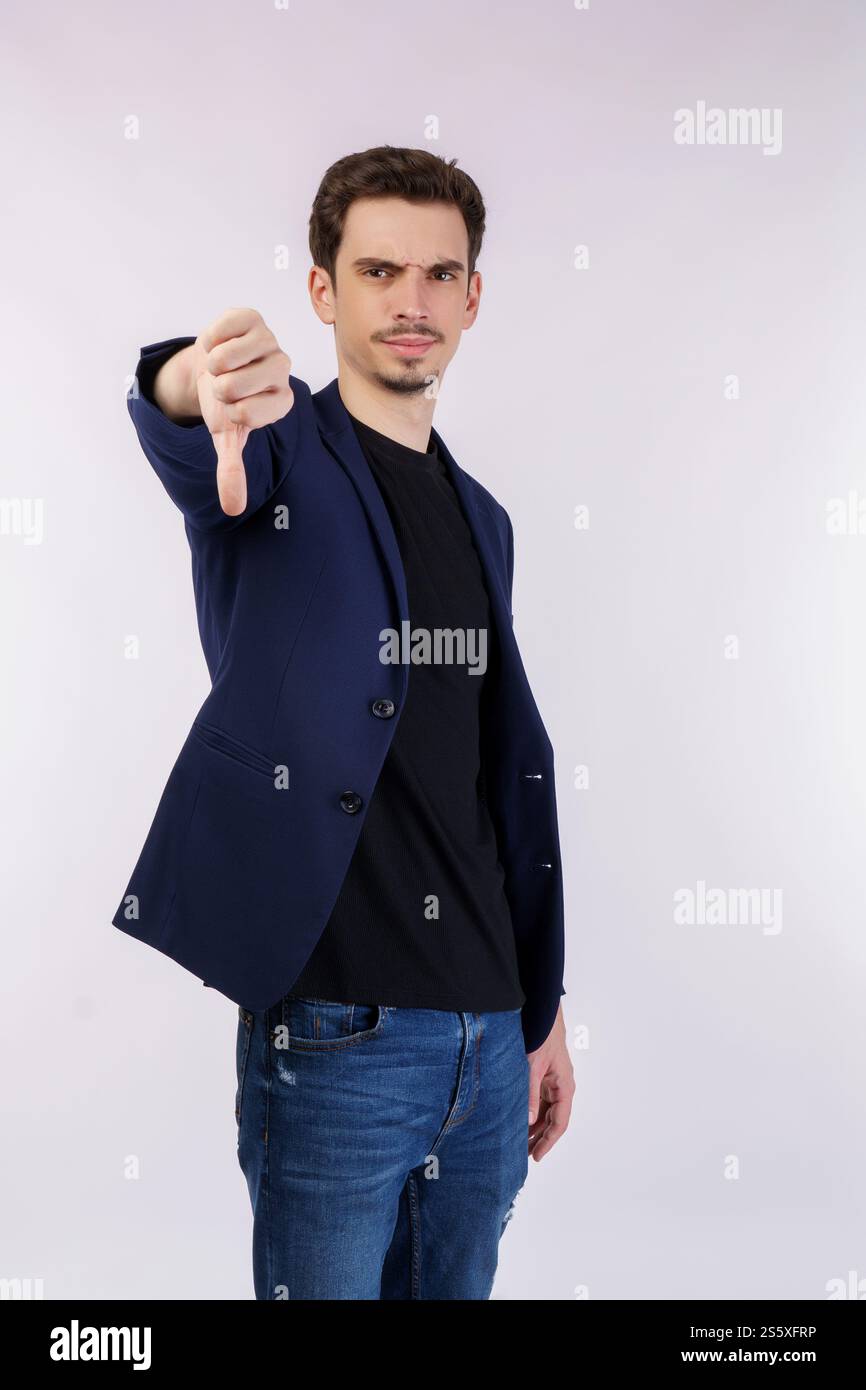 Portrait of young businessman shows sign of dislike, looks with ...