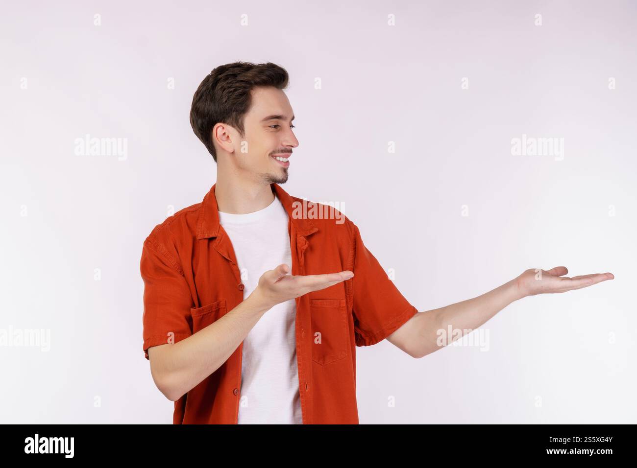 Portrait of happy smiling young man presenting and showing your text or ...