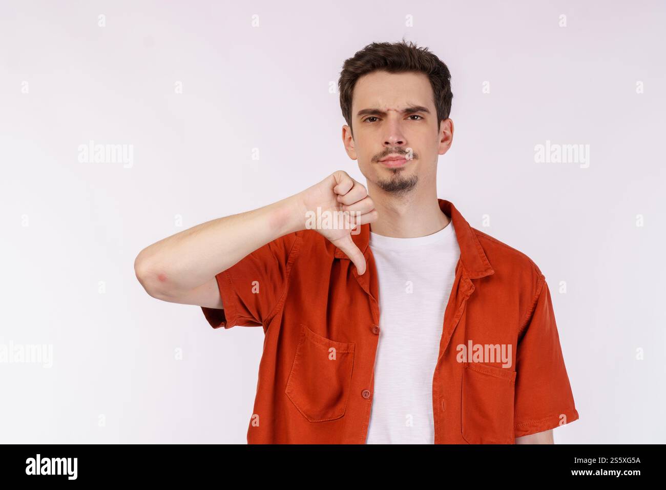 Portrait of young man shows sign of dislike, looks with negative ...