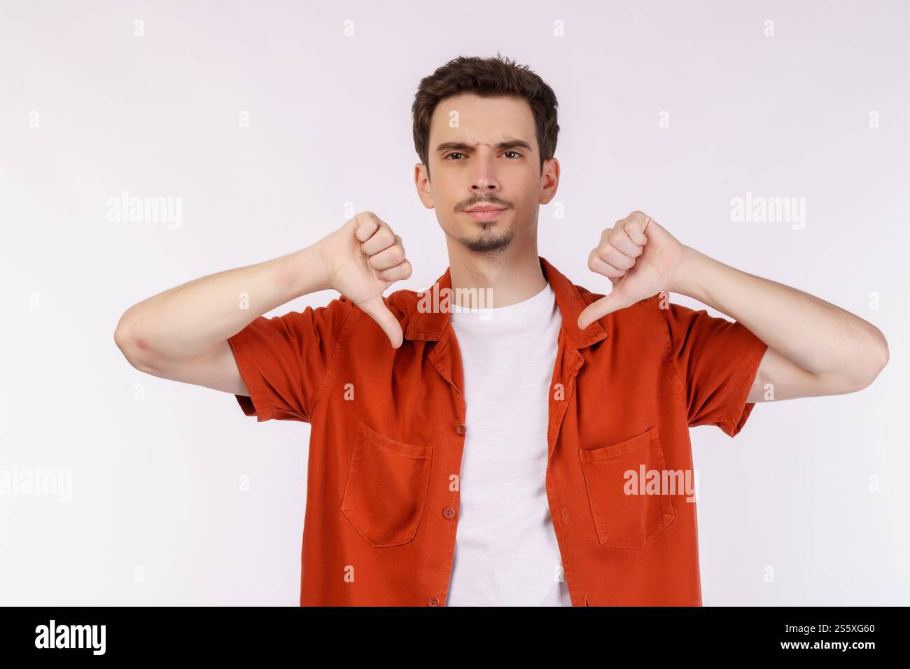 Portrait of young man shows sign of dislike, looks with negative ...