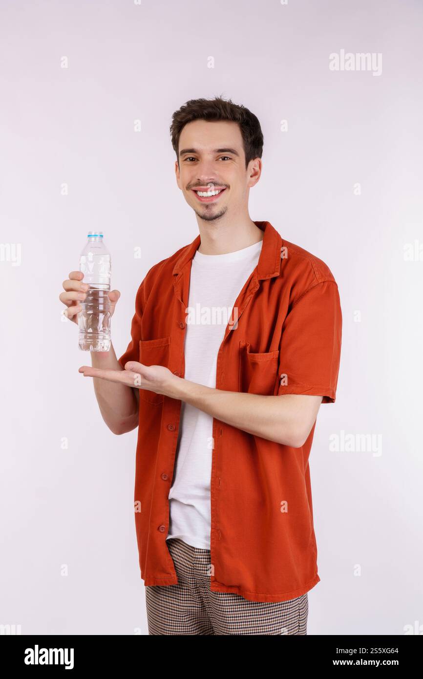 Portrait of Happy young man showing water in a bottle isolated over ...