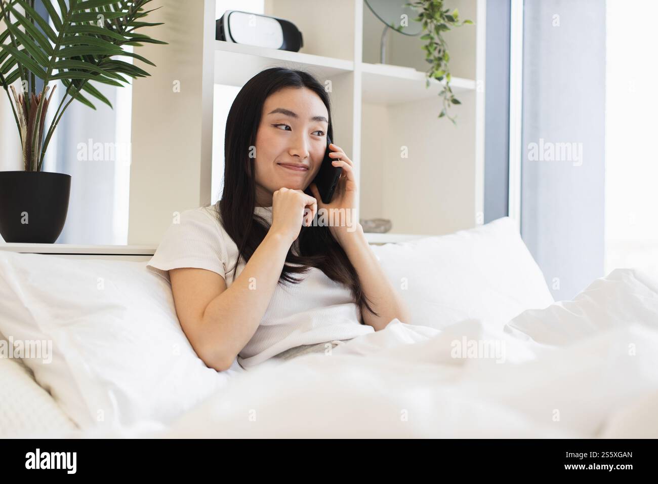 Asian woman in her 20s having phone call while resting on comfortable ...