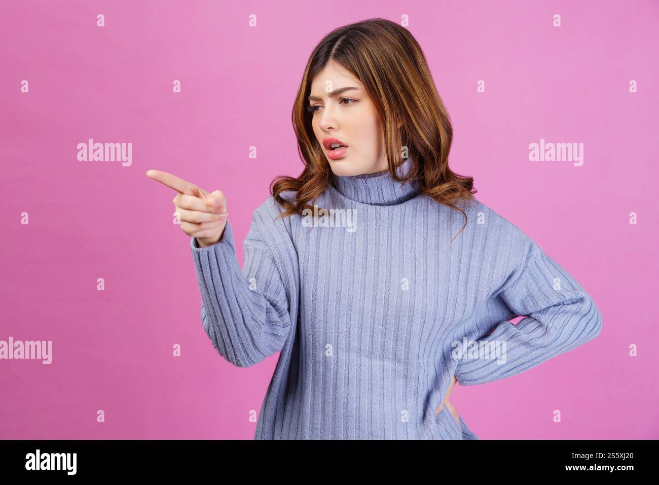 Portrait of angry sad young woman point index finger aside isolated ...