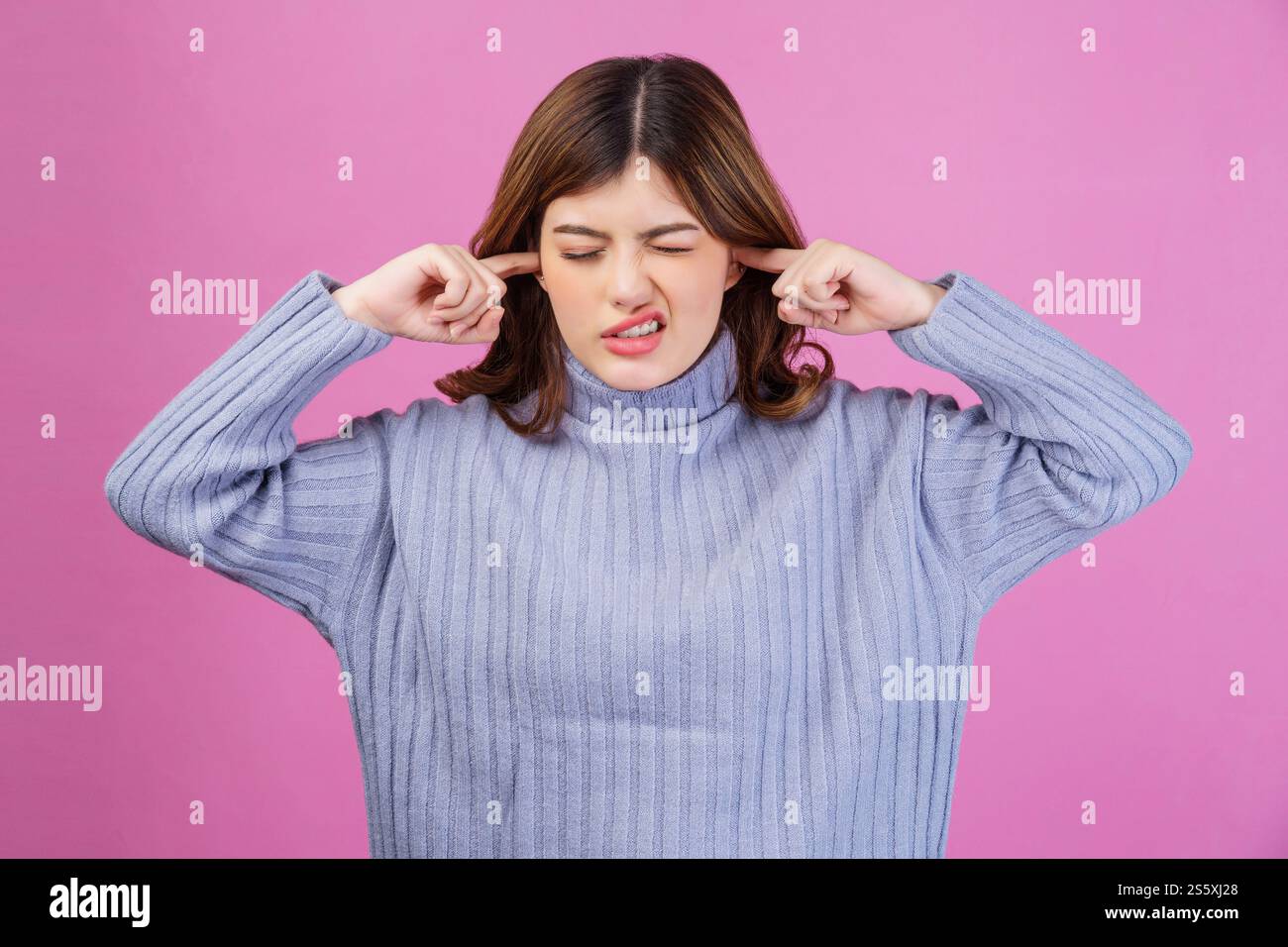 Portrait of Annoyed woman sticking plug fingers in ears not listening ...