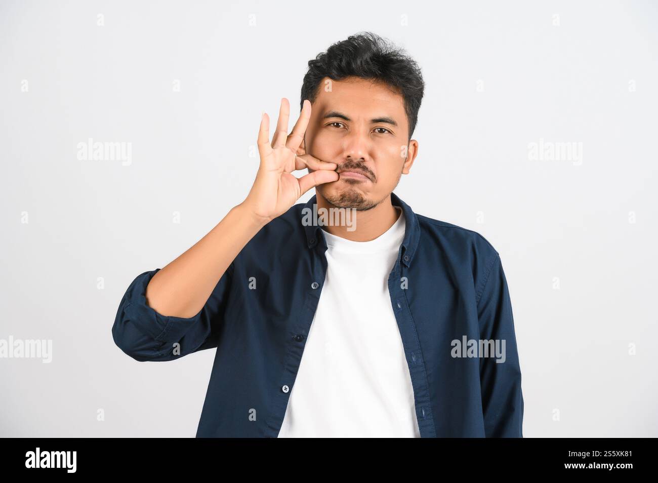 Portrait of Young asian man in blue shirt keeping a secret isolated on ...