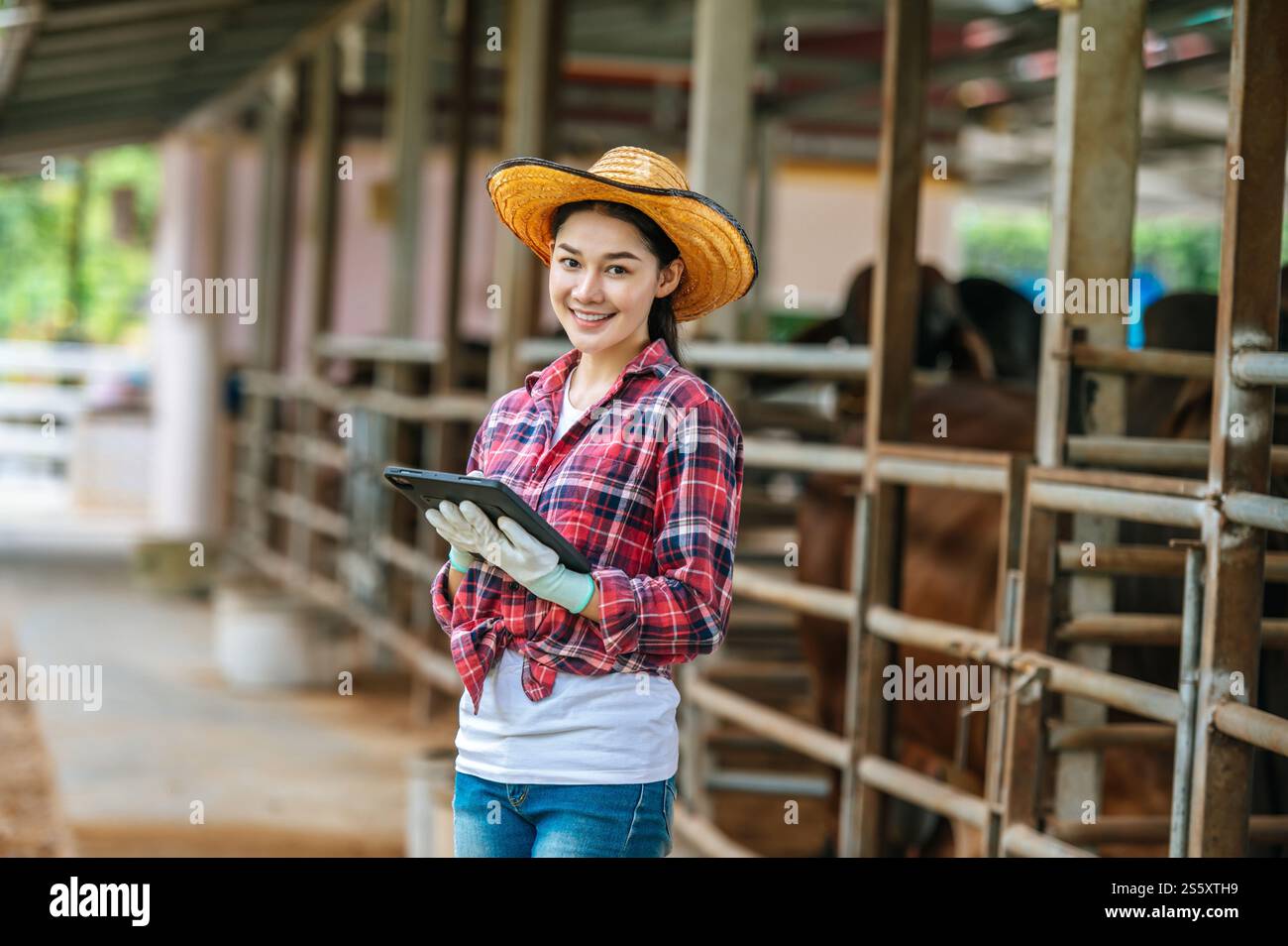 Happy Asian young farmer woman with tablet pc computer while standing ...