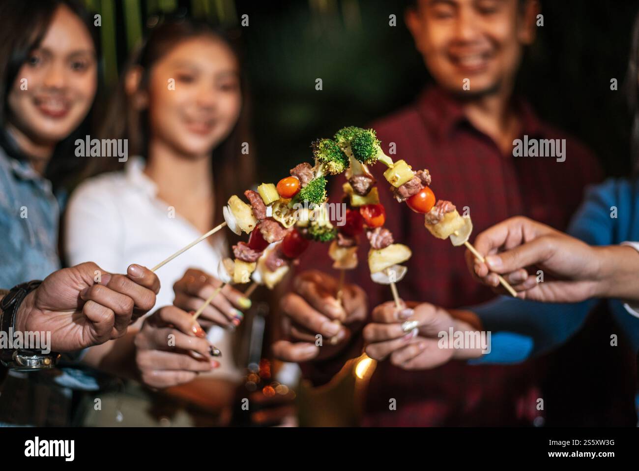 Happy Asian friends cheering with barbecue dinner outdoor - Group of ...