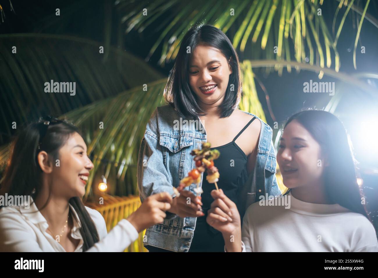 Happy Asian friends cheering with barbecue dinner outdoor - Group of ...