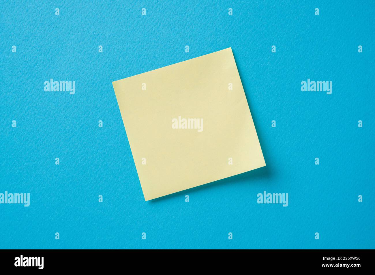 blank yellow sticky note on a blue background Stock Photo - Alamy