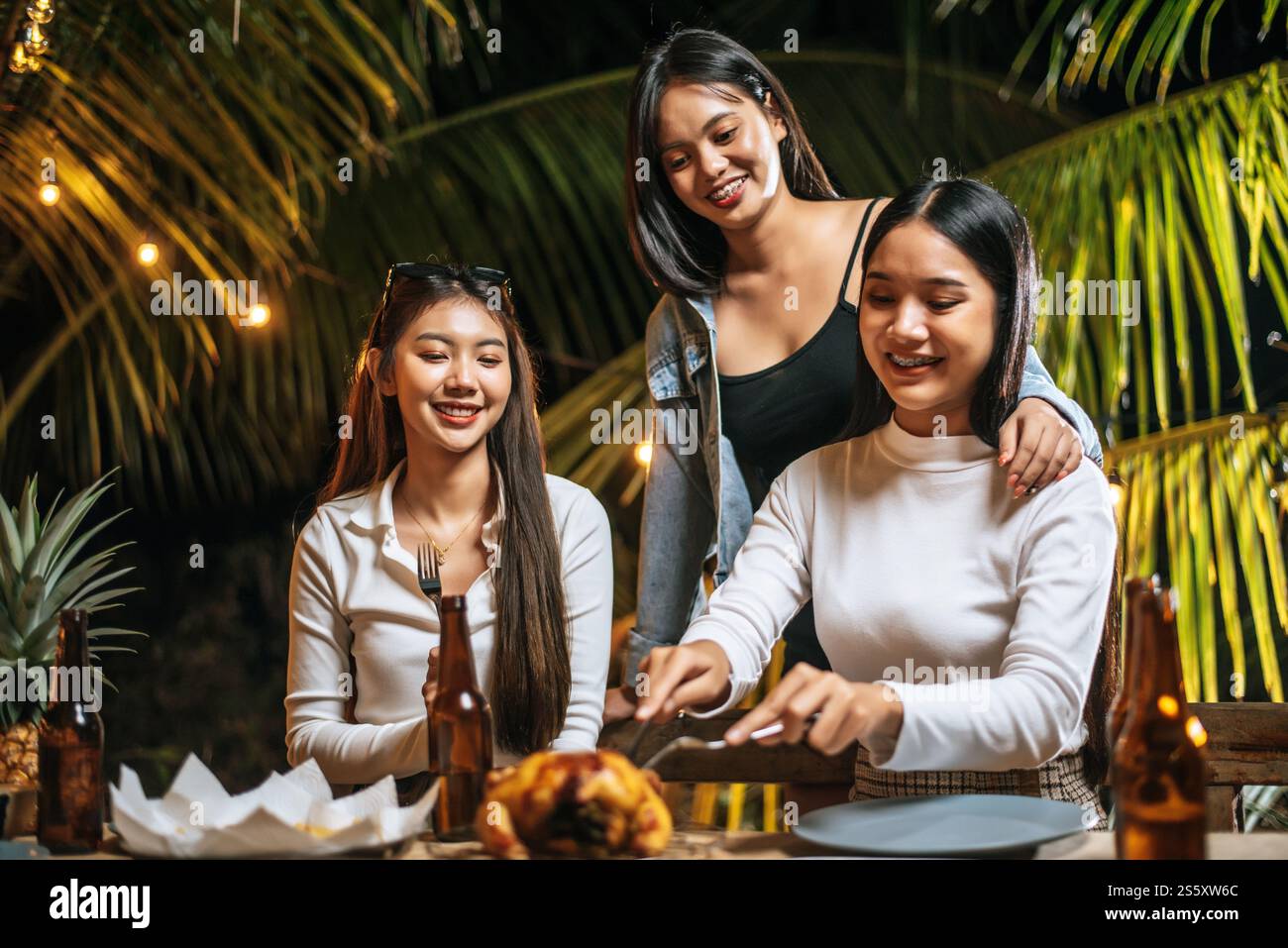Happy Asian friends cheering with roasted turkey dinner outdoor - Group ...