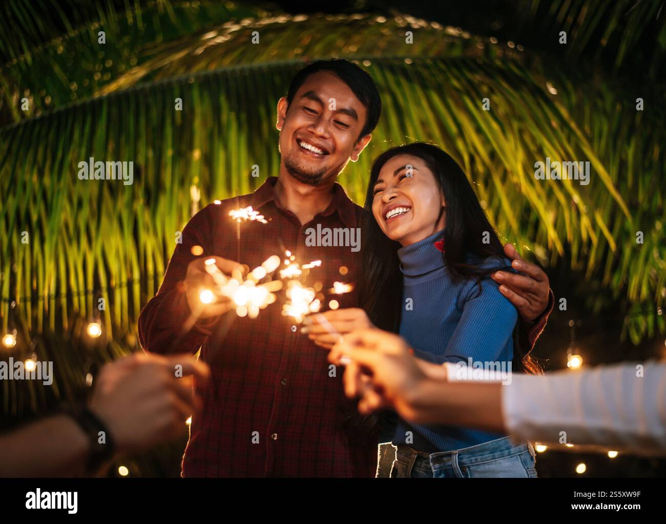 Portrait of Happy Asian group of friends having fun with sparklers ...