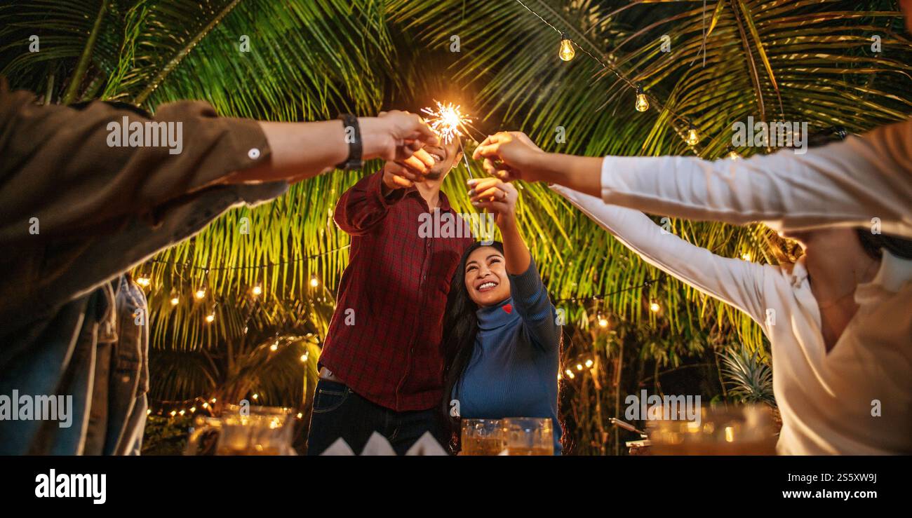 Portrait of Happy Asian group of friends having fun with sparklers ...