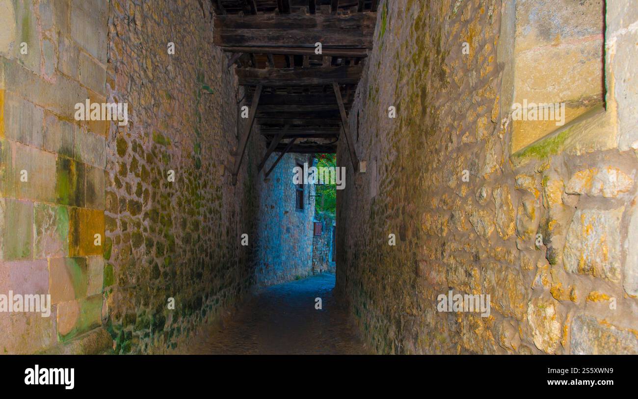 Passage between two stone houses under a wooden ceiling in an ancient ...