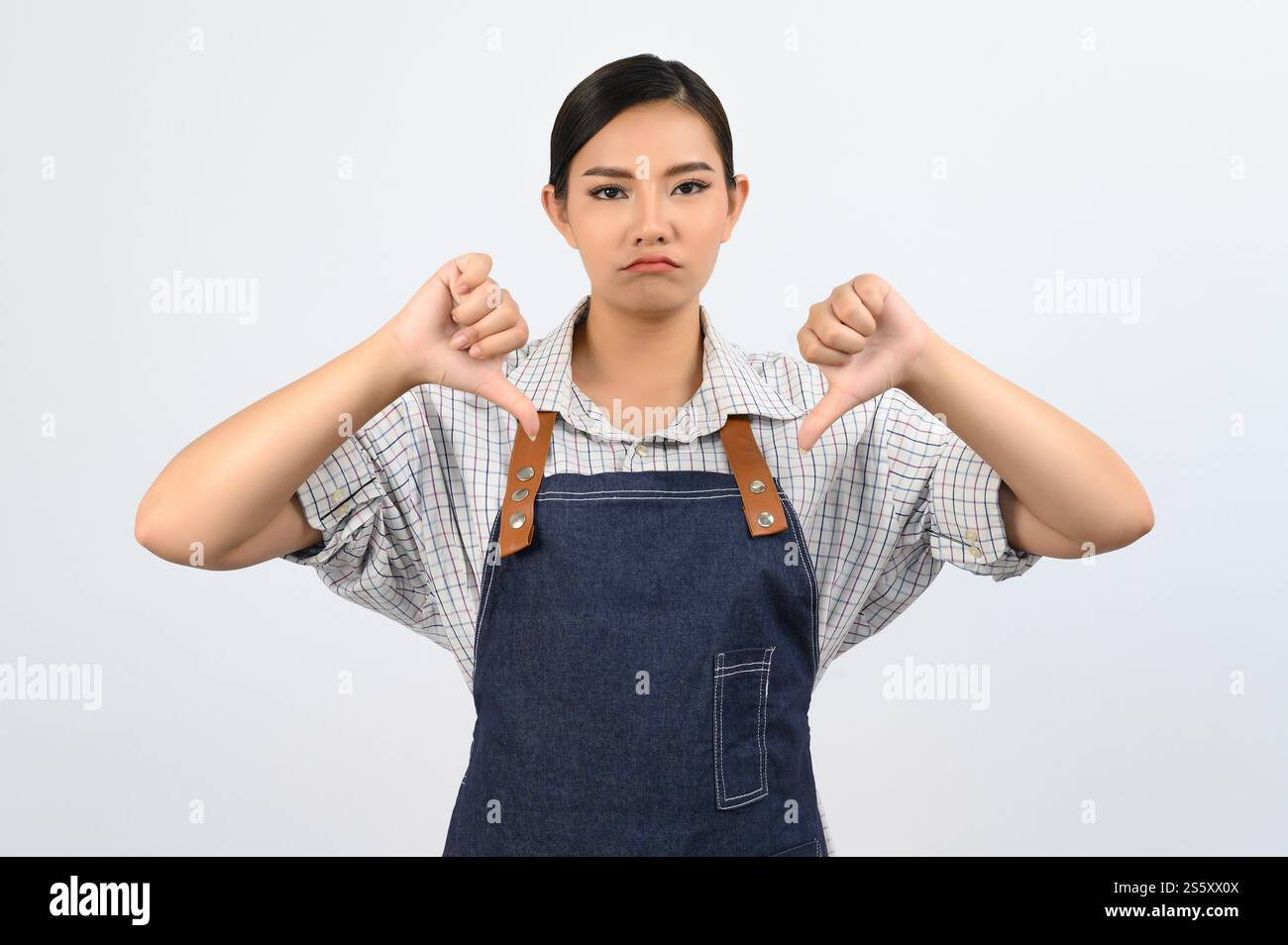 Portrait Asian young woman in waitress uniform and apron standing ...