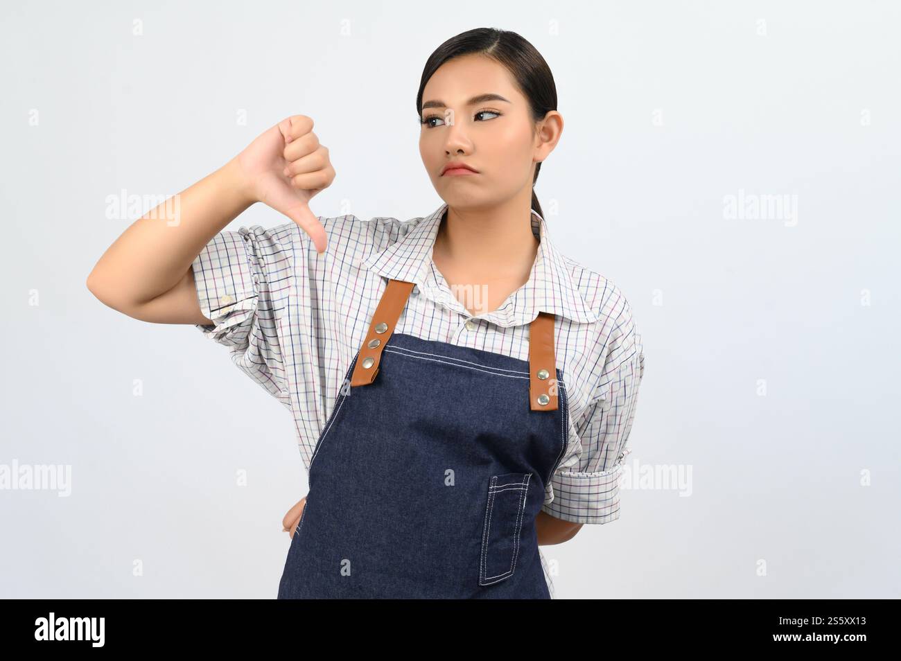 Portrait Asian young woman in waitress uniform and apron standing ...