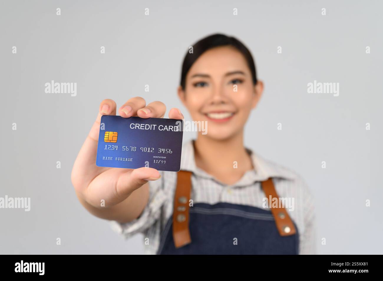 Selective focus, Credit card in hand of young asian woman in waitress ...