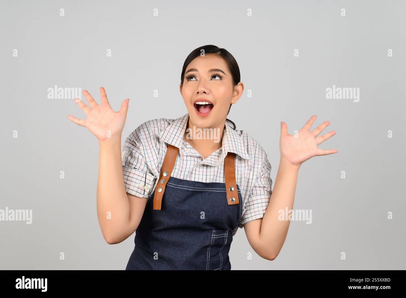 Portrait Asian young woman in waitress uniform with open palm posture ...